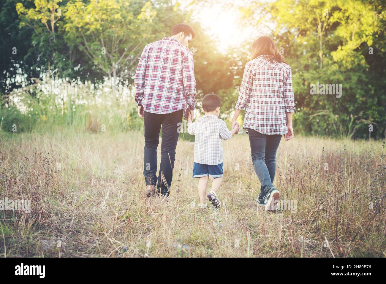 Rear of young family spending good time together. Family outdoors in ...