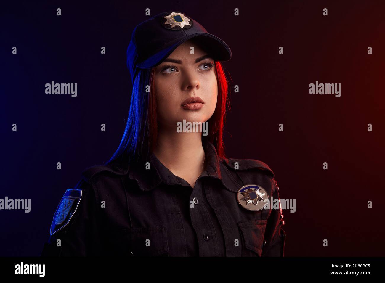 Close-up shot of serious female police officer posing for the camera ...