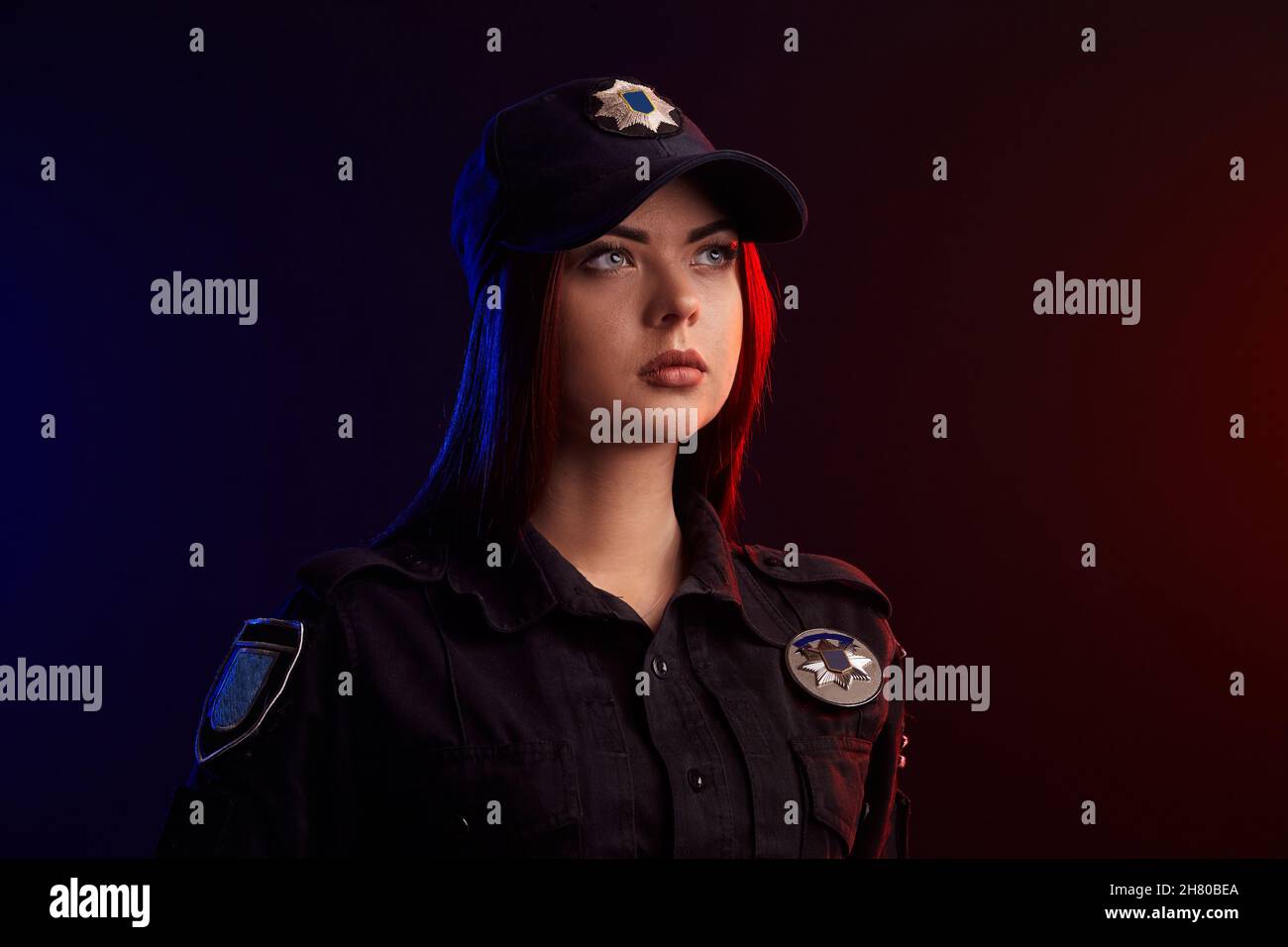 Close-up shot of serious female police officer posing for the camera ...