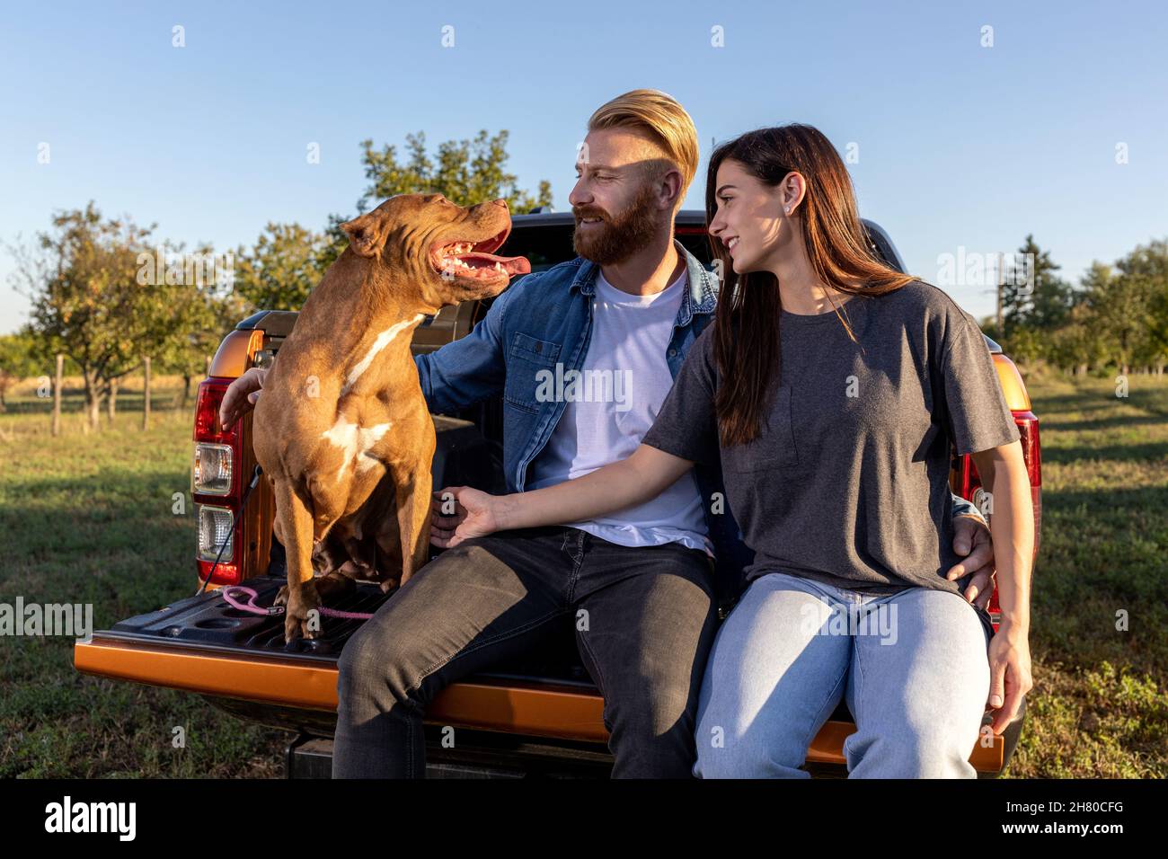 Cute young couple with a dog Stock Photo - Alamy