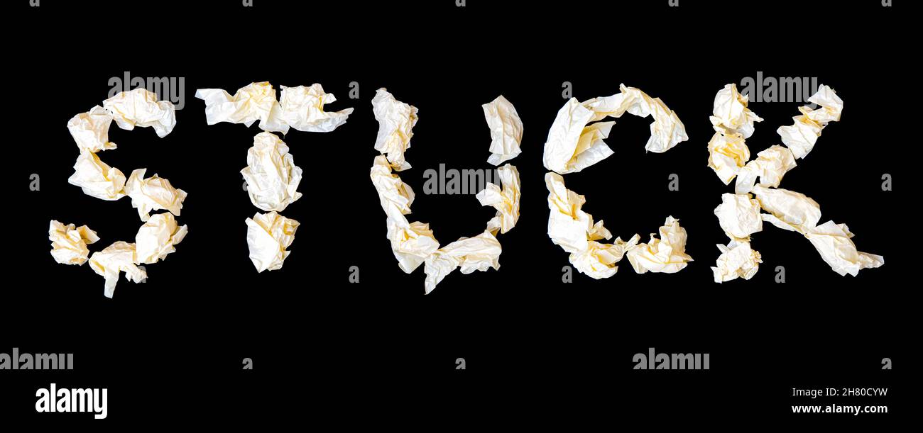 Word STUCK made of crumpled paper balls isolated on black. Getting ...