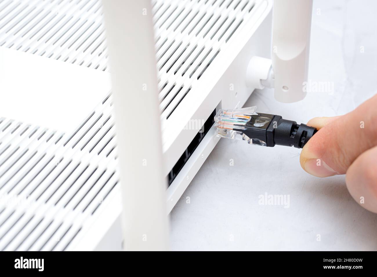 Man plugging internet cable into the router Stock Photo - Alamy