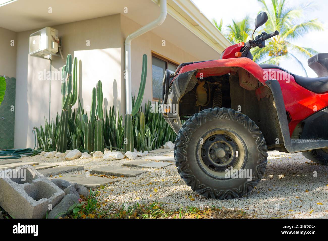 Low angle view of a quad bike parked by a house in tropics Stock Photo ...