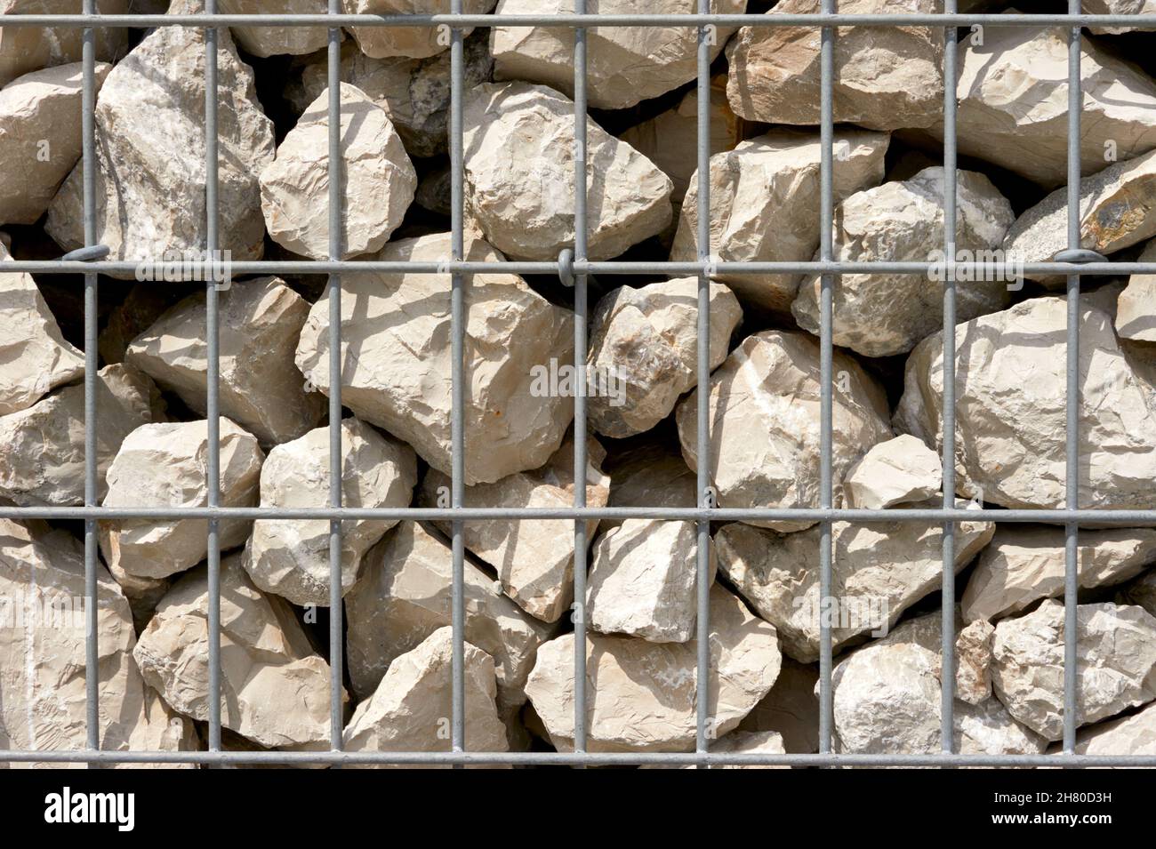 Stones behind the metal bars background Stock Photo - Alamy