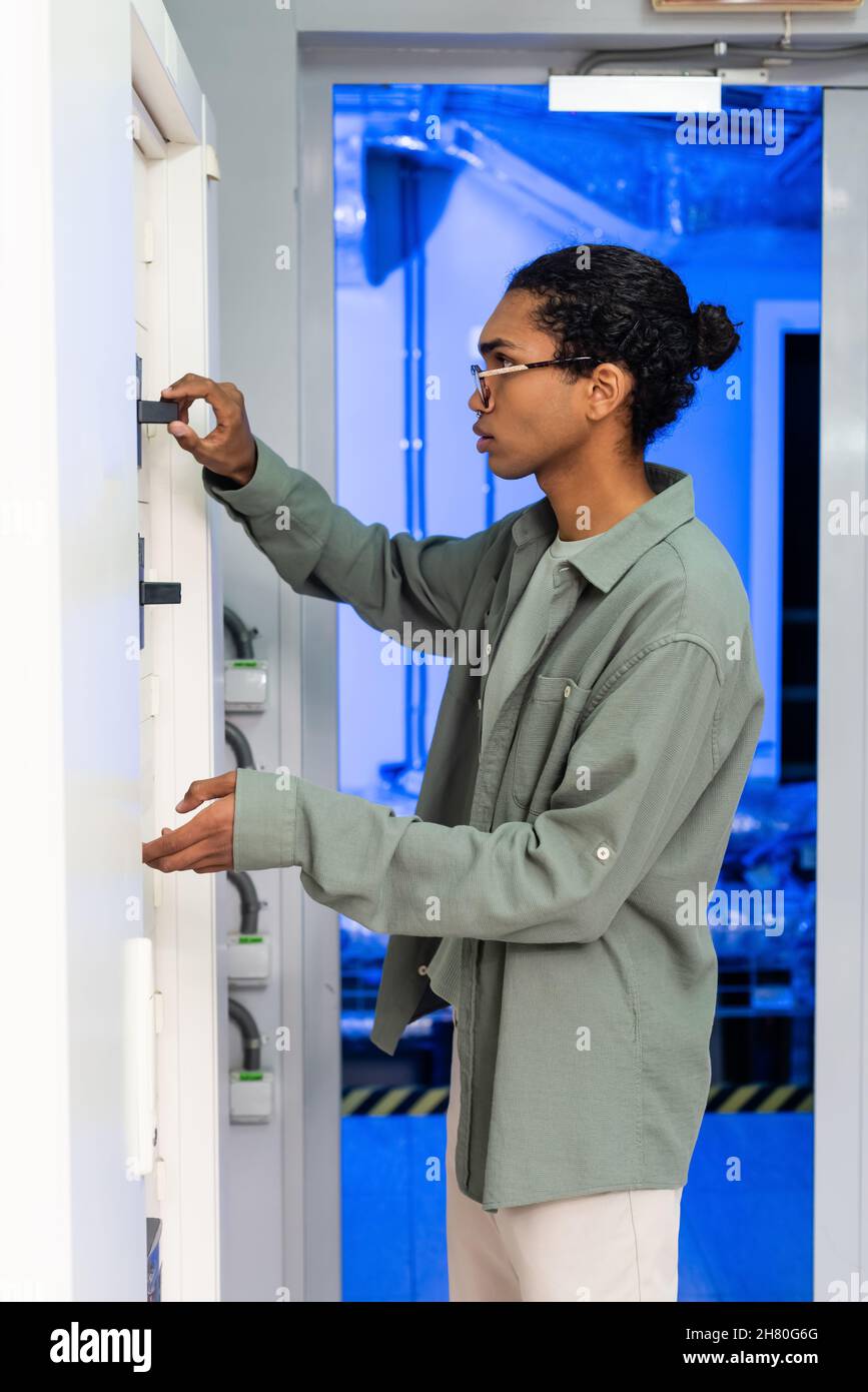 side view of african american technician making maintenance of ...