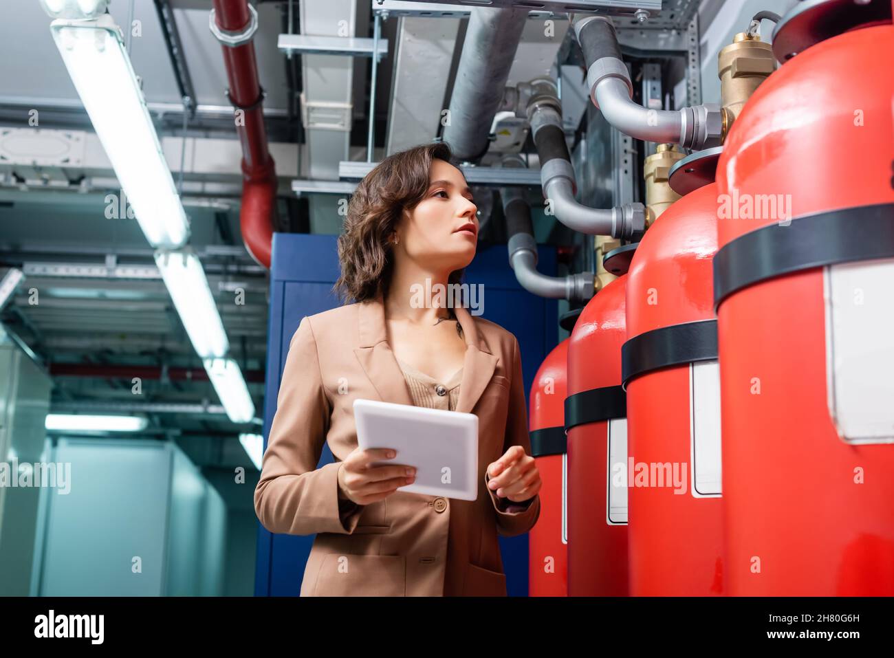 technician with digital tablet checking technical equipment in data ...