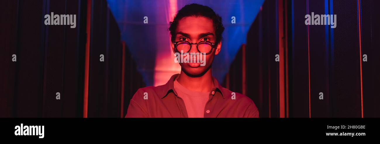 young african american engineer looking at camera in data center with ...