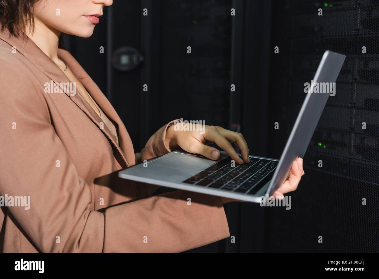 cropped view of programmer using laptop while working near servers in data center Stock Photo ...