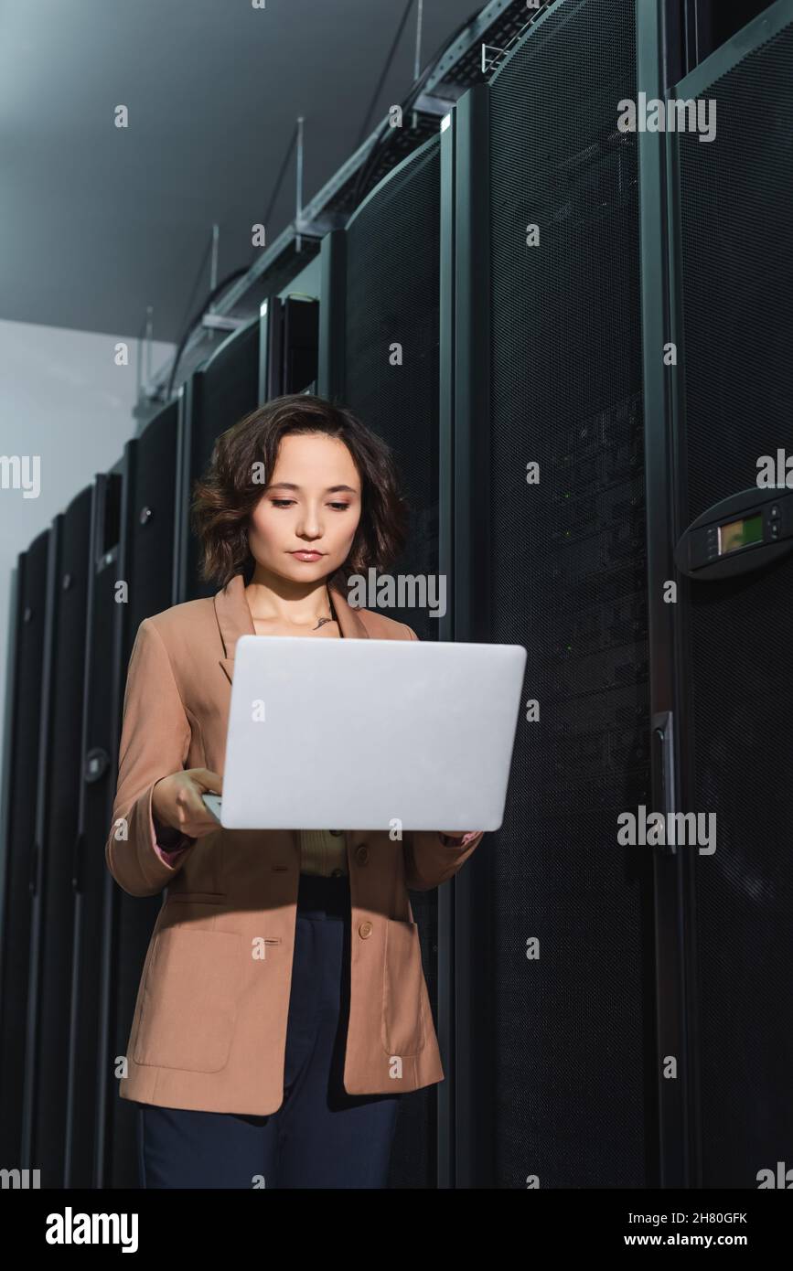 young programmer looking at laptop while working in data center Stock ...