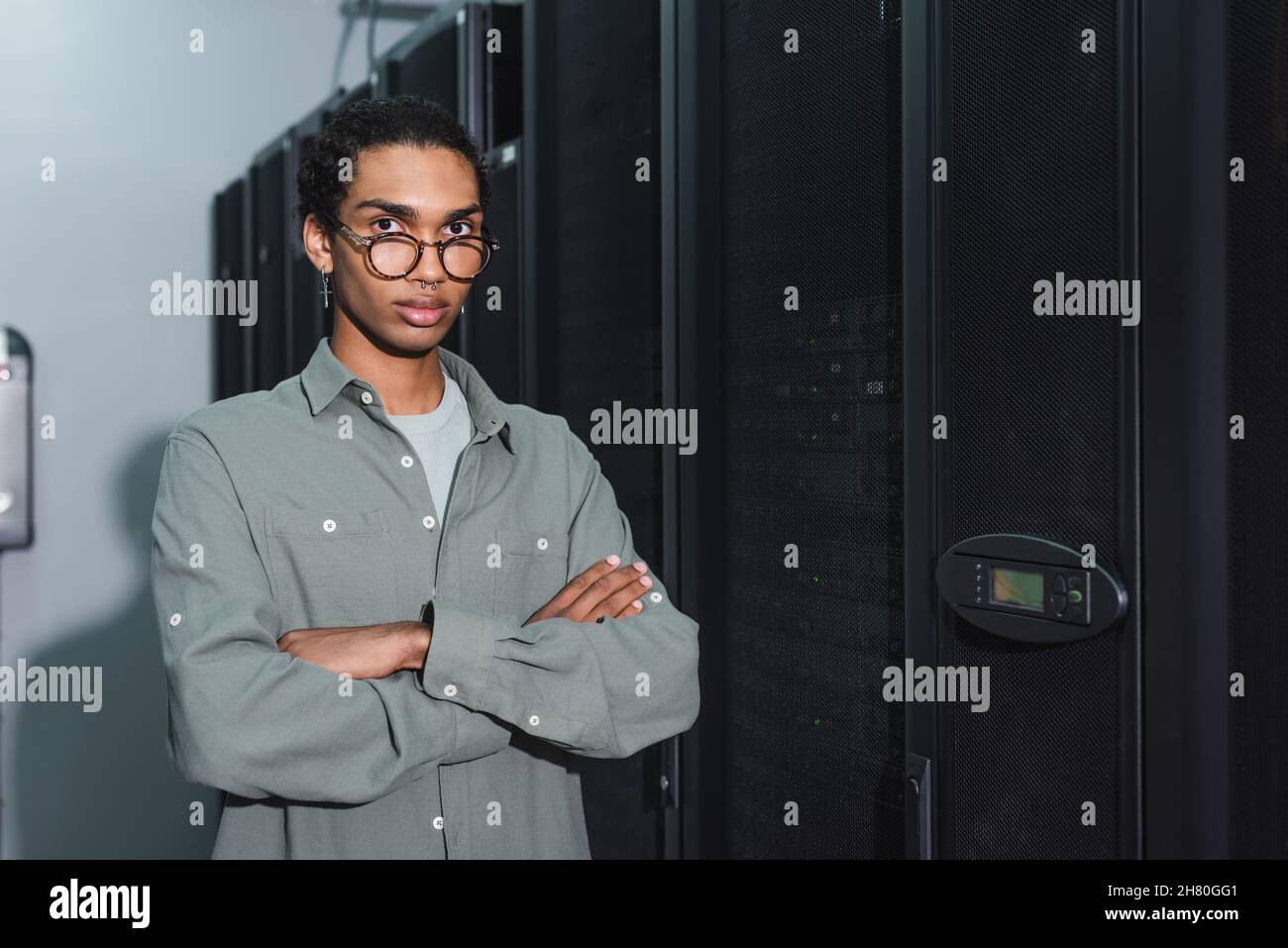 african american programmer in eyeglasses standing with crossed arms ...