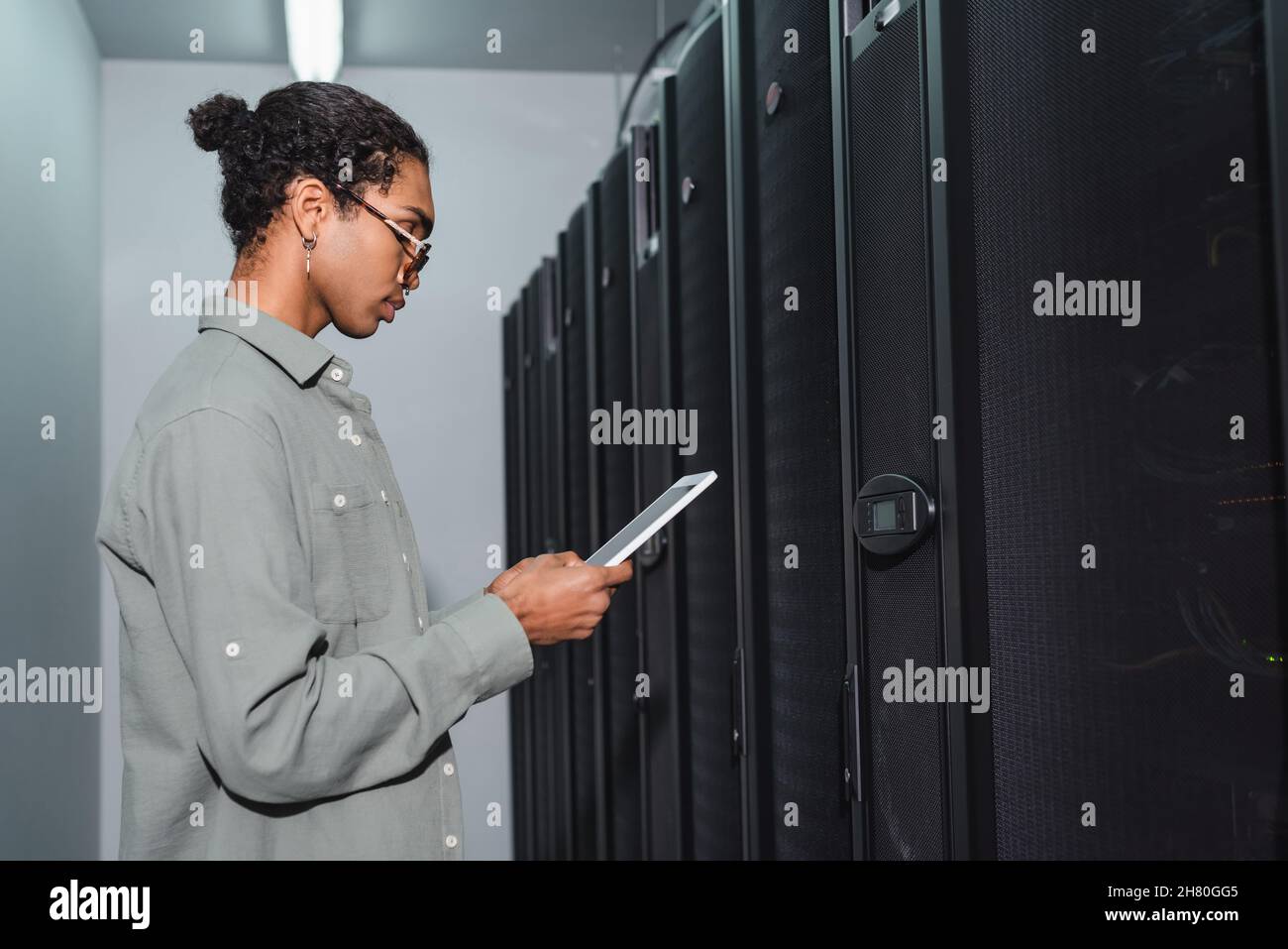 side view of african american programmer with digital tablet standing ...