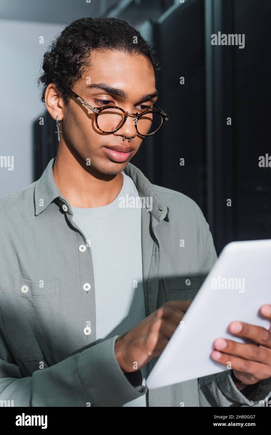 african american programmer looking at digital tablet during work in ...