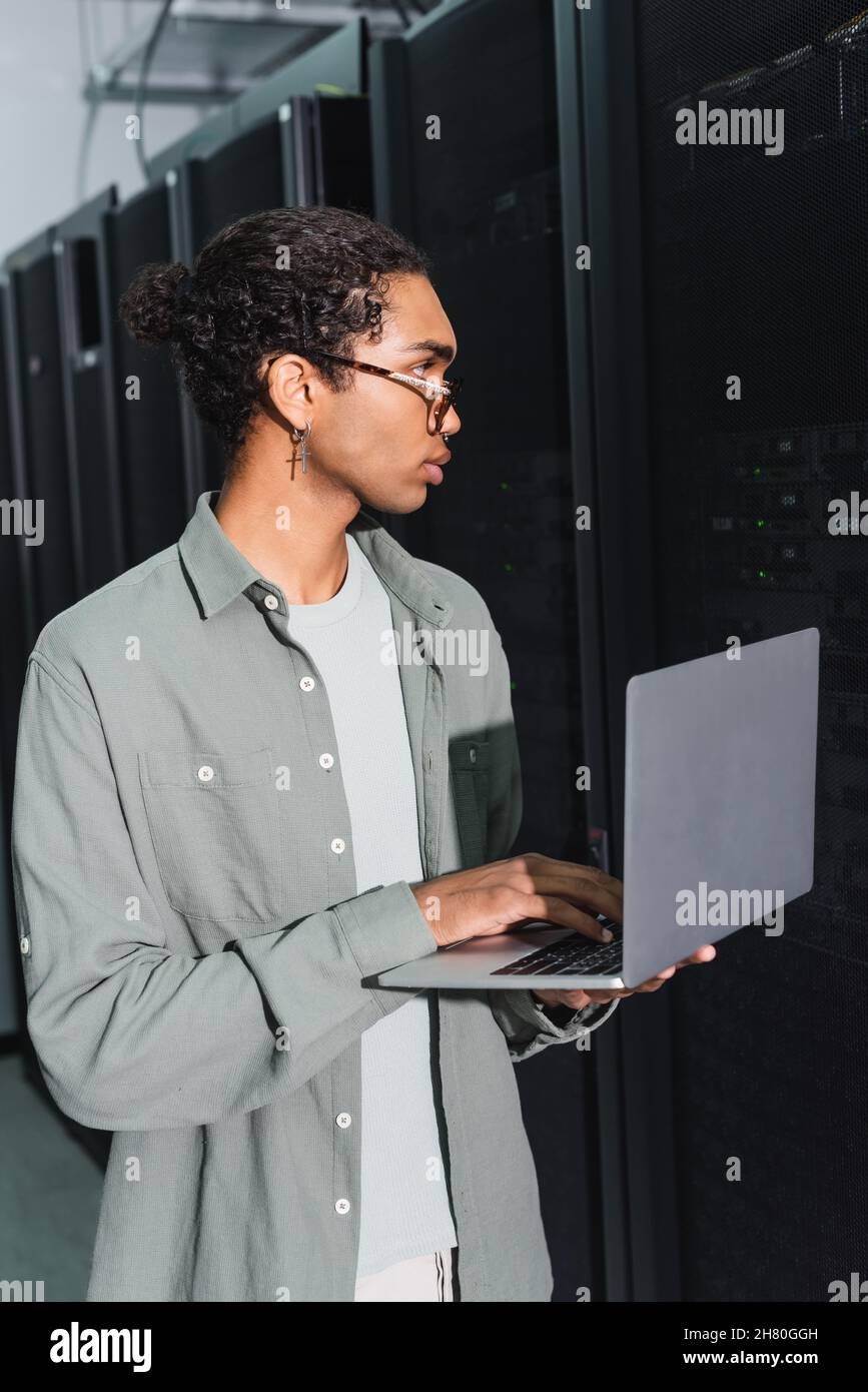 young african american programmer using laptop while working with ...