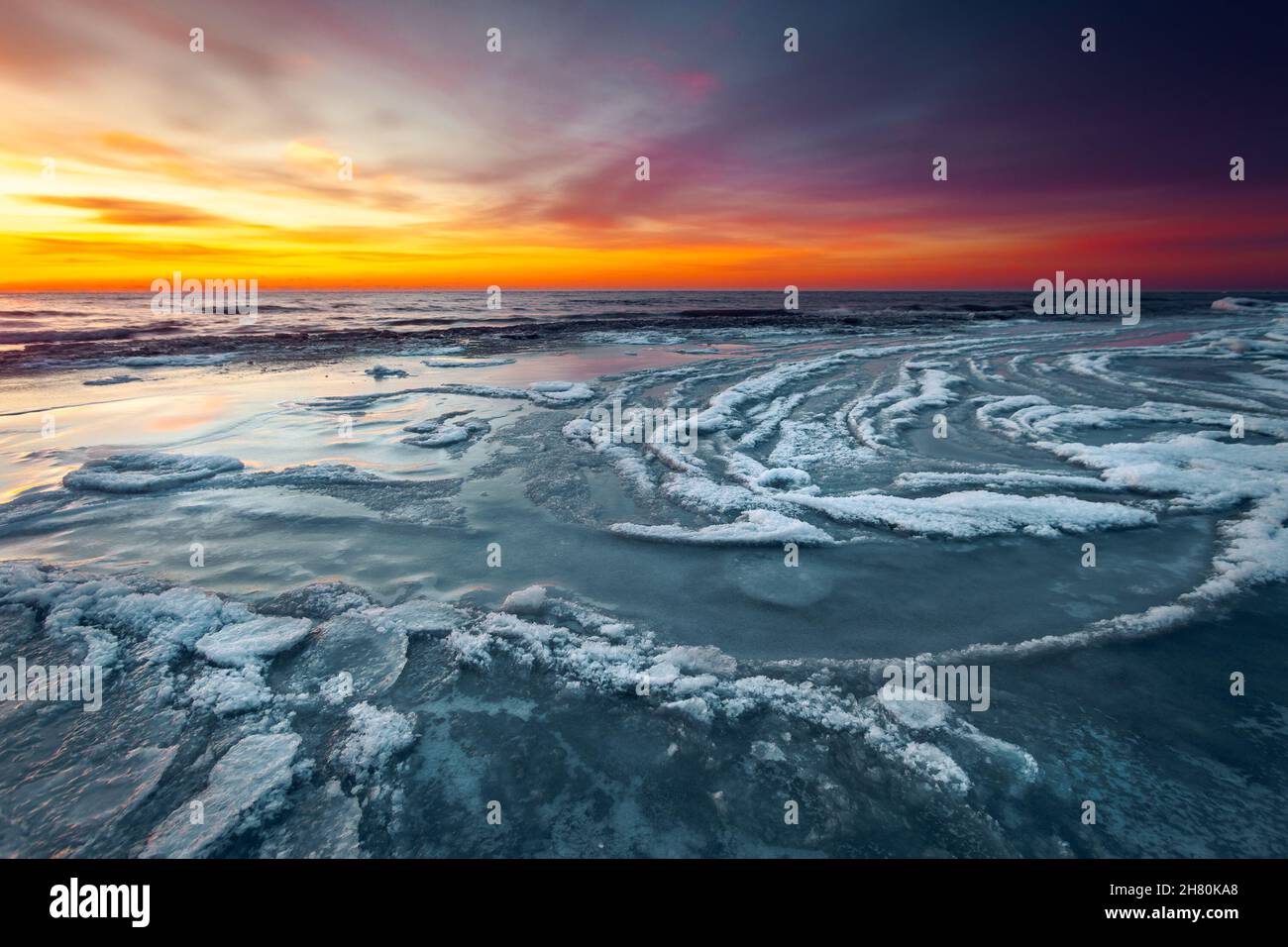 Bright colorful sunset at the coast of the Baltic Sea in Lithuania with ...