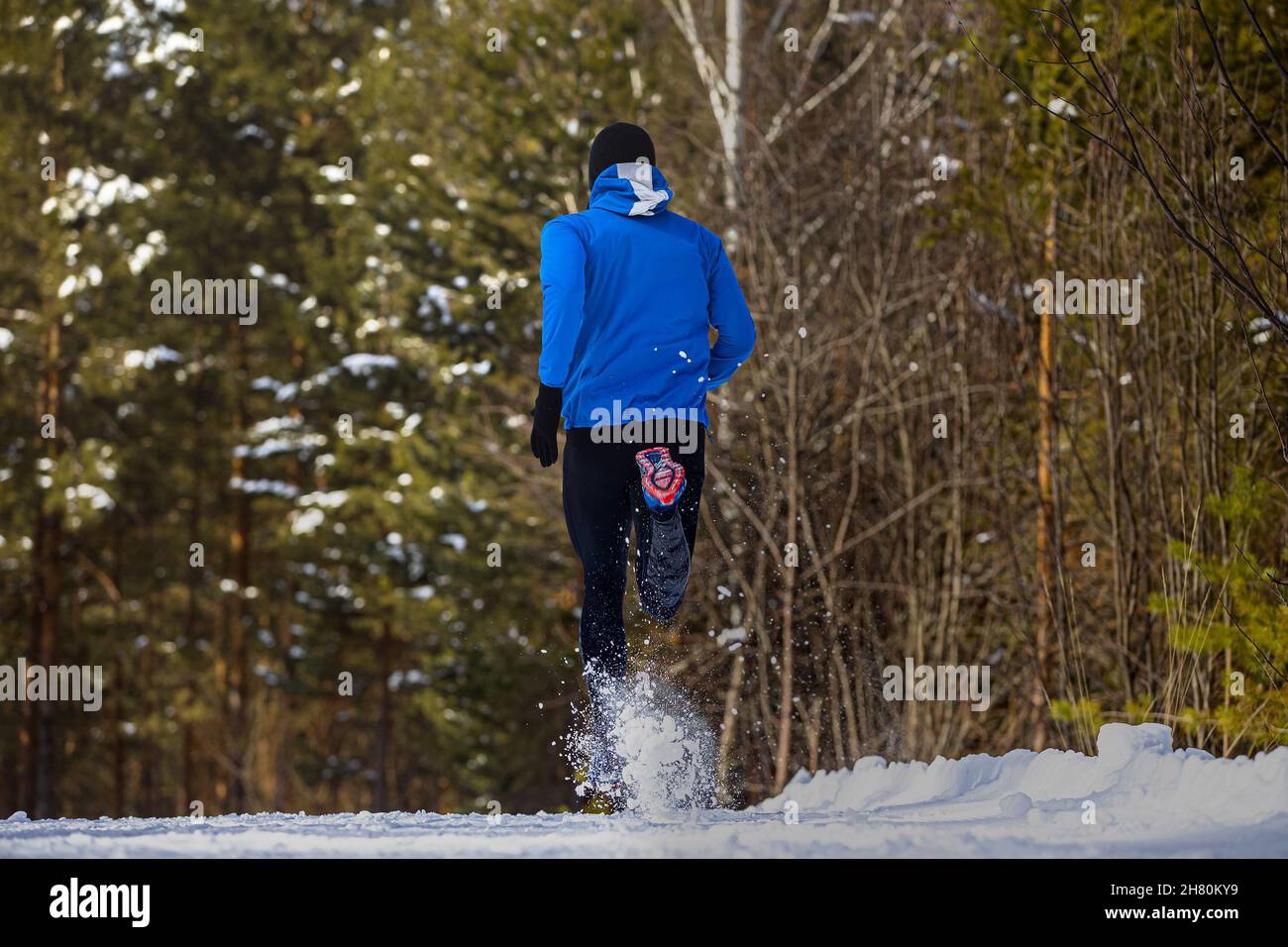 back runner athlete running winter forest trail Stock Photo - Alamy