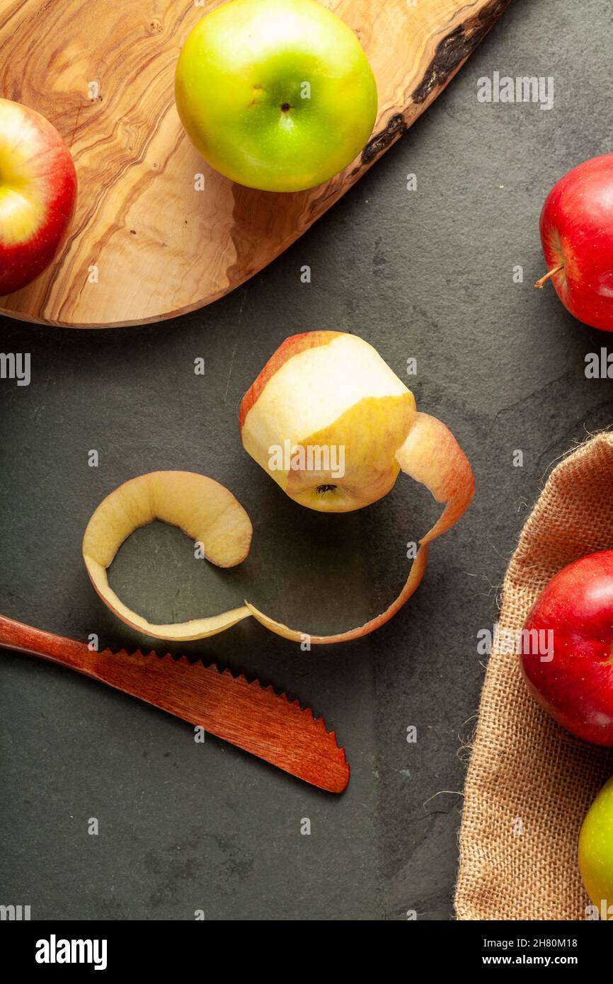 apples of different varieties are seen on dark stone and wooden ...