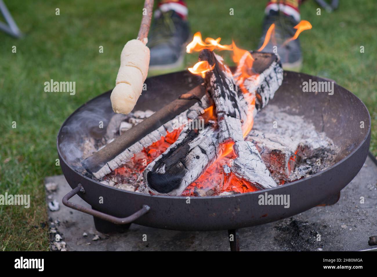 Bread on a stick over a campfire in a steel shell Stock Photo - Alamy
