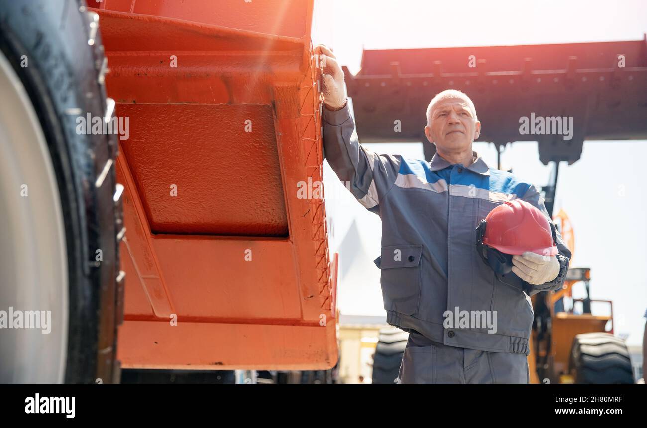 Driver man of construction equipment excavator or tractor. Builder or ...