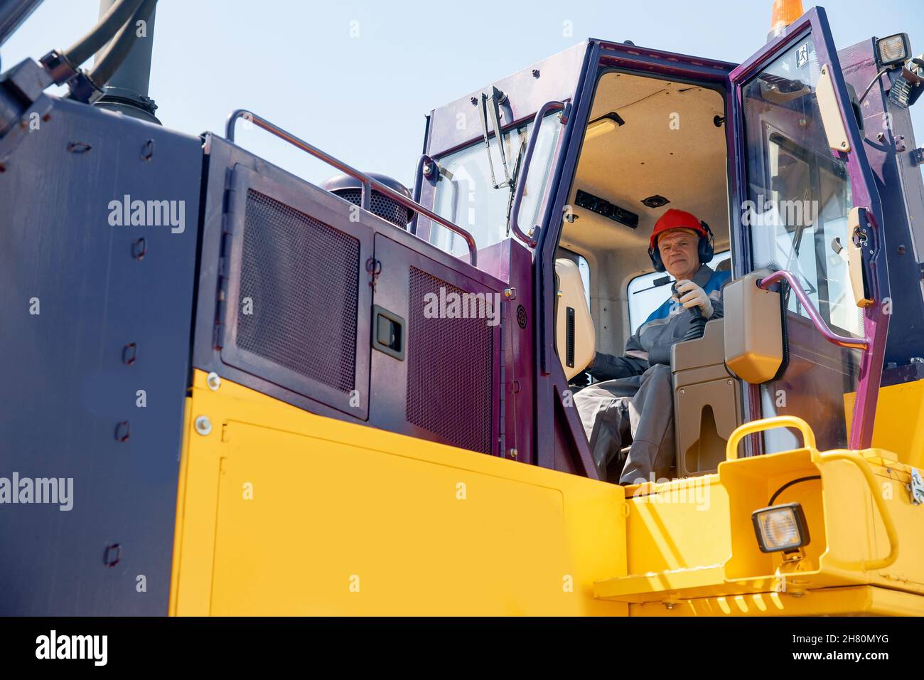 Industrial bulldozer driver gets into coal loading cab in open pit mine ...