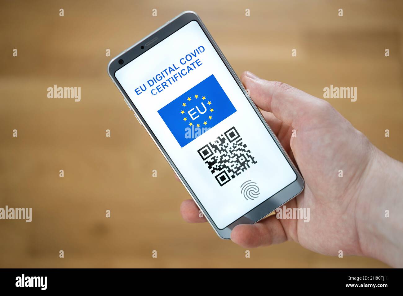 Hand holding a smartphone with EU Greenpass digital covid certificate ...
