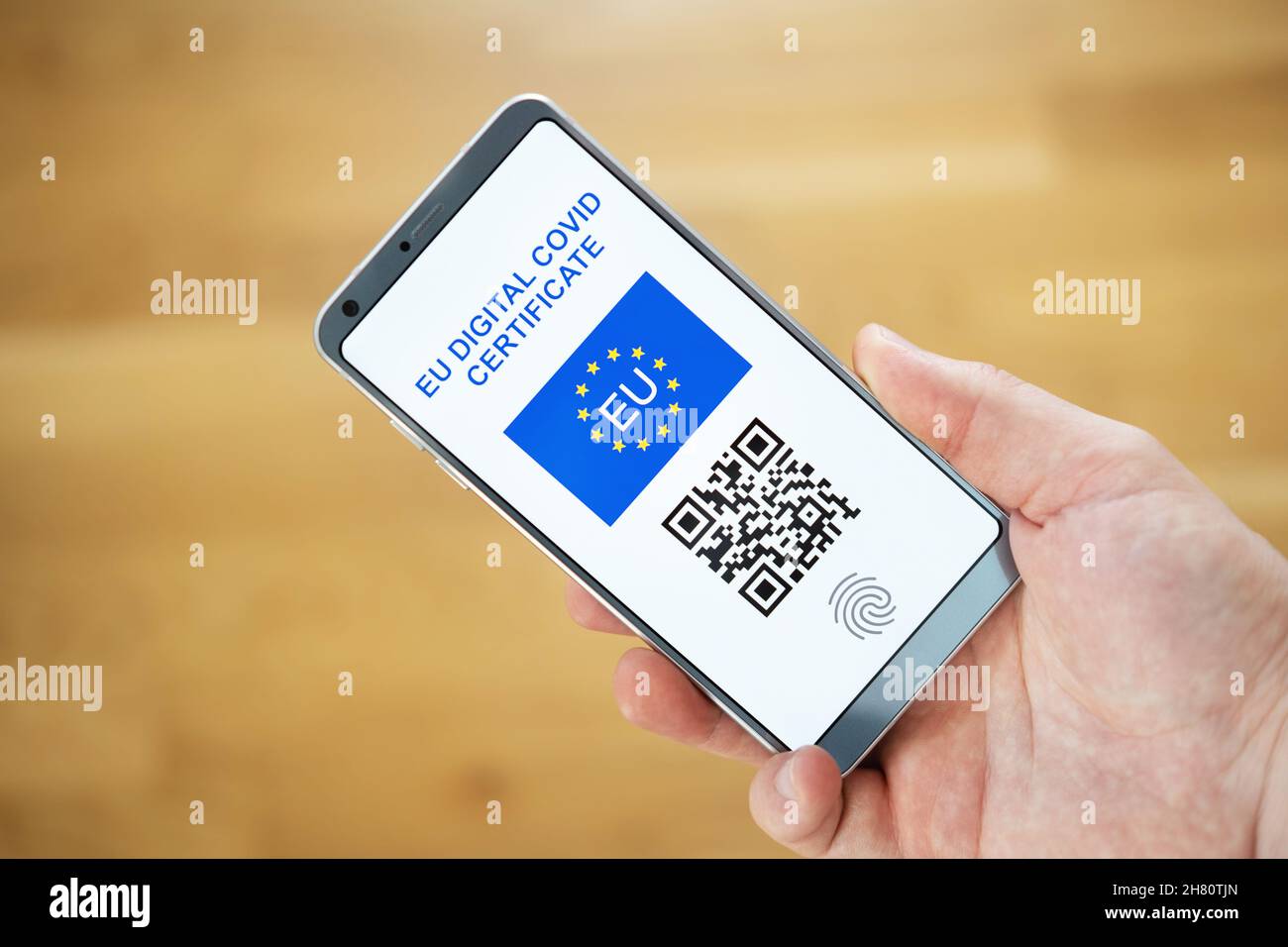 Hand holding a smartphone with EU Greenpass digital covid certificate ...