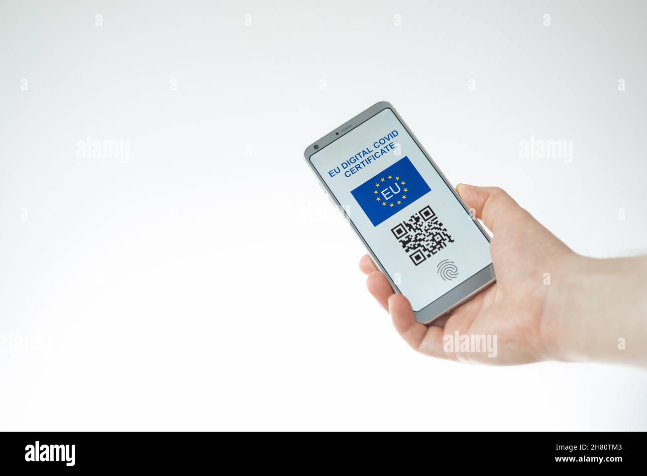 Hand holding a smartphone with EU Greenpass digital covid certificate ...