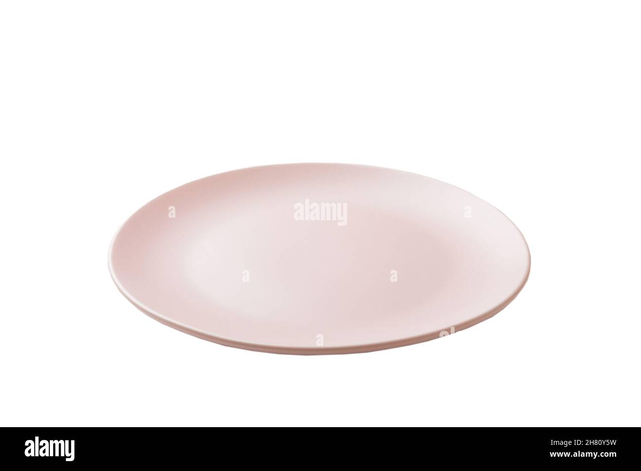 Pink ceramic round plate isolated over white background. perspective ...