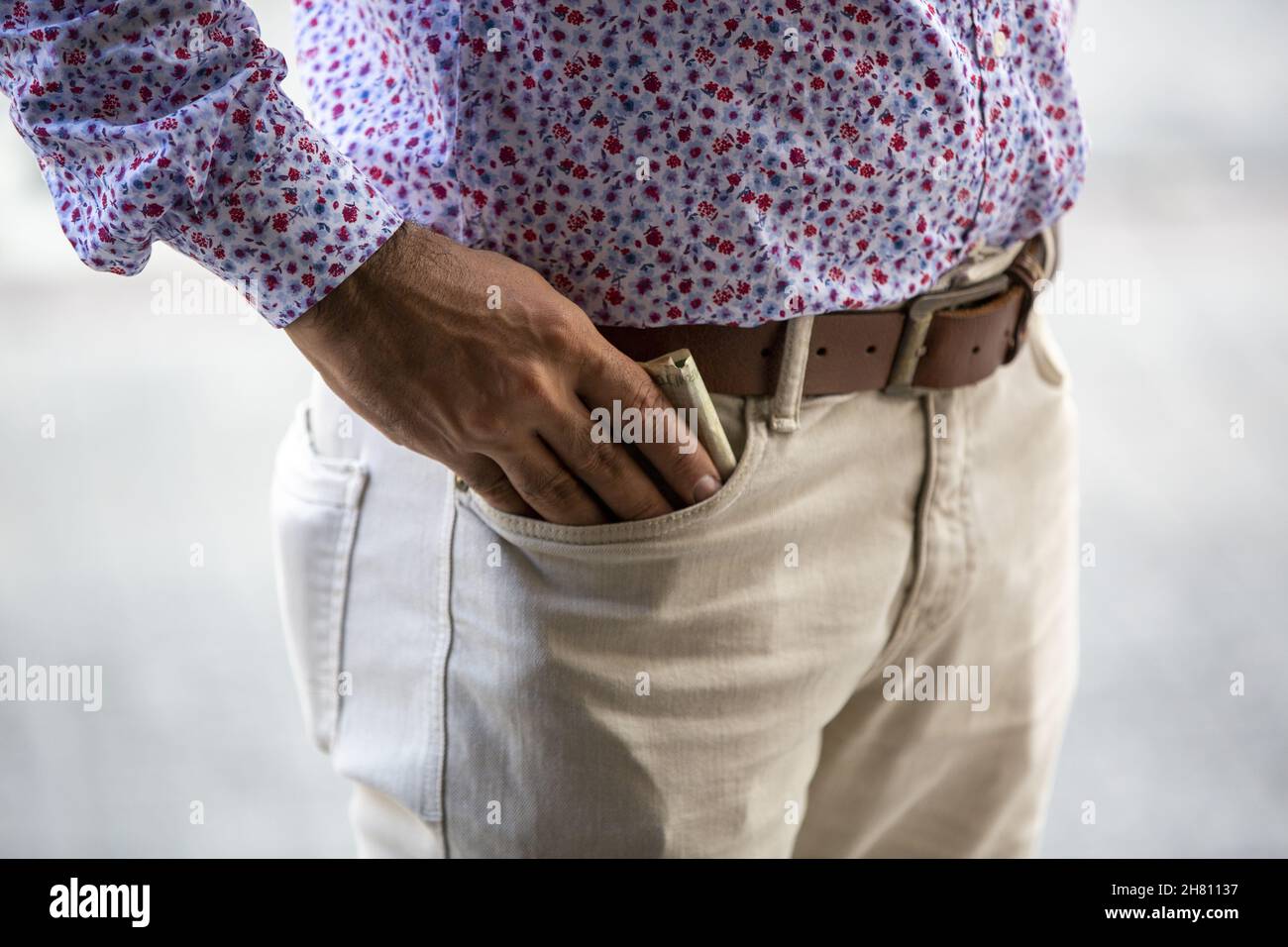 Man pulling money out of his pocket Stock Photo - Alamy