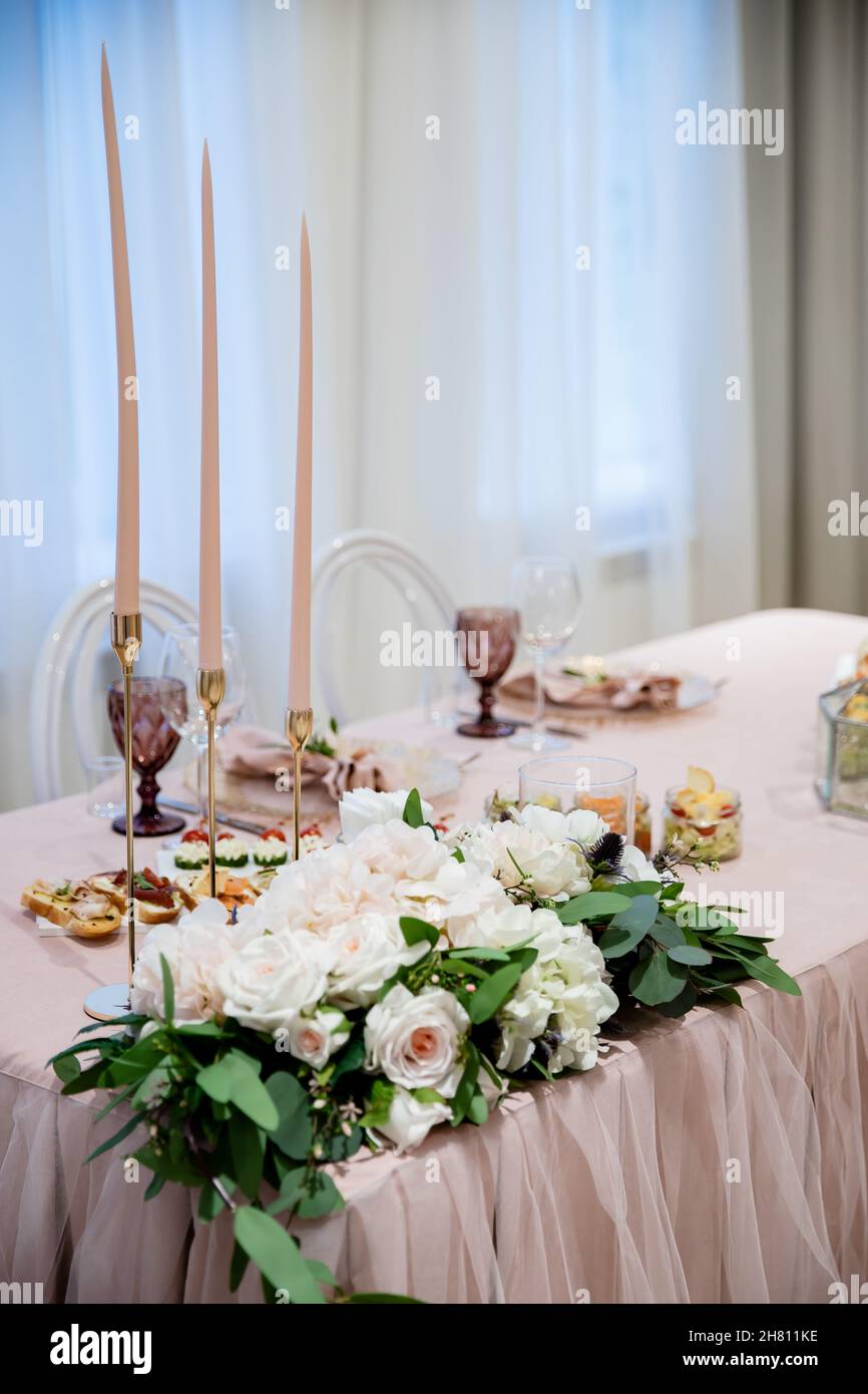 Wedding catering table in powdery pink color. Different food appetizers ...