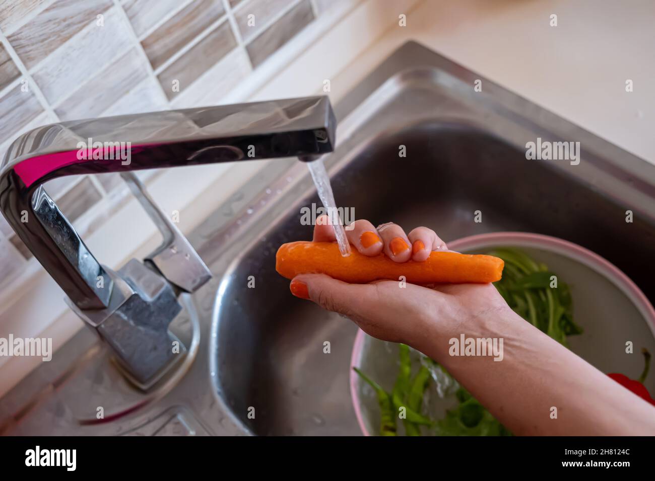 Woman washing fresh vegetables in the kitchen Stock Photo - Alamy