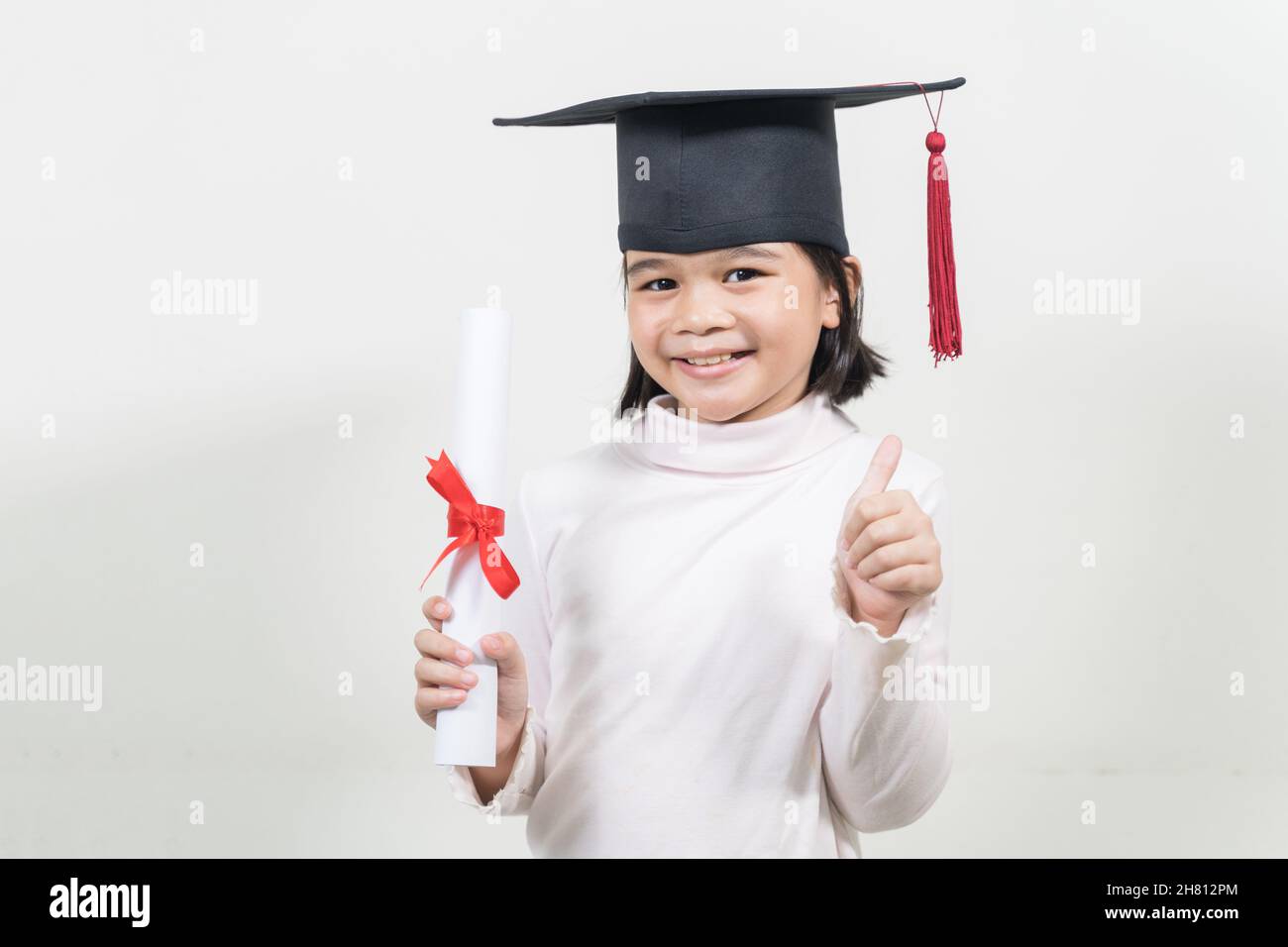 Happy Thai kid with a graduation hat and diploma isolated on white ...