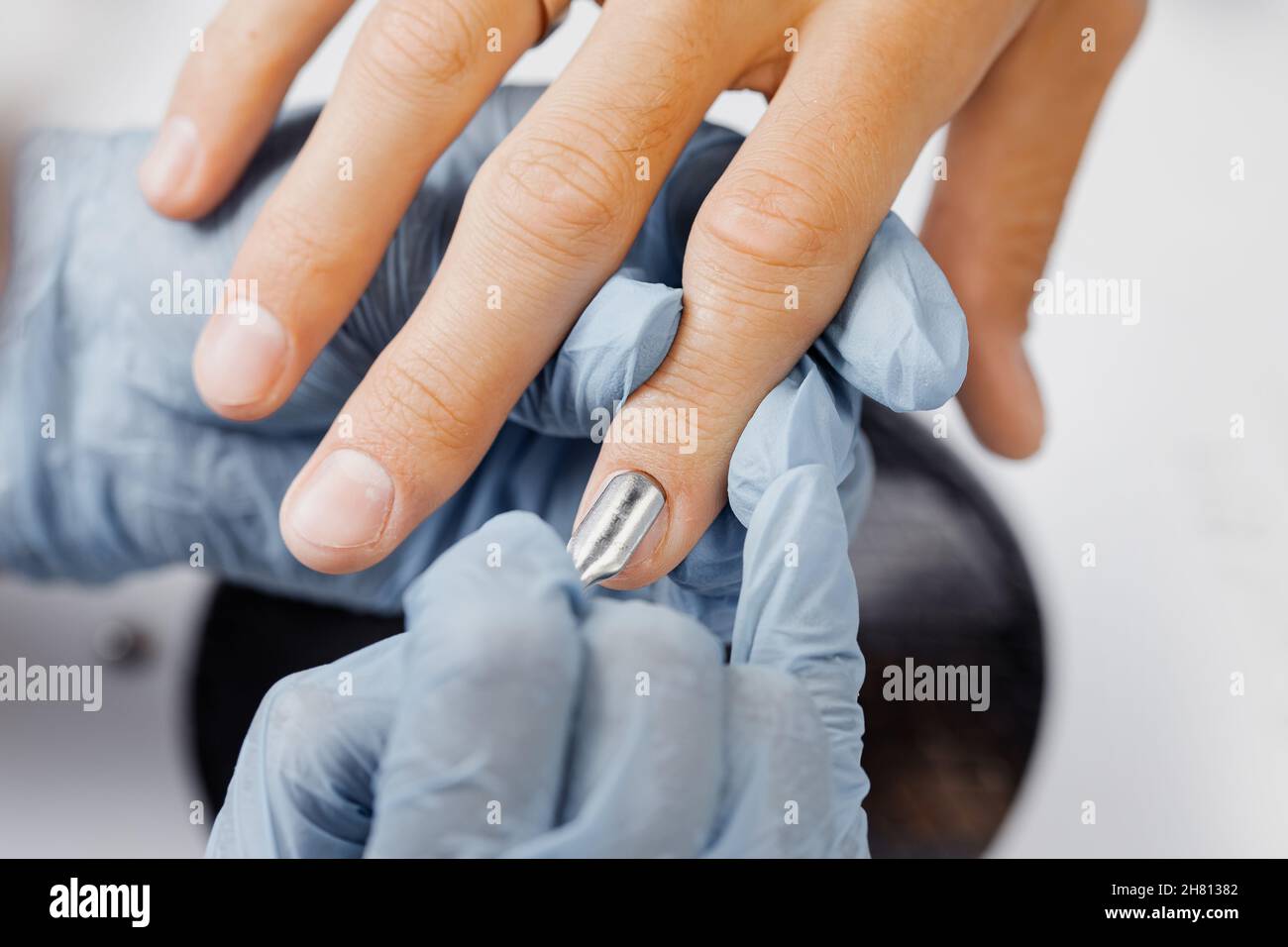 Closeup hands of young man gets professional manicure in spa salon ...