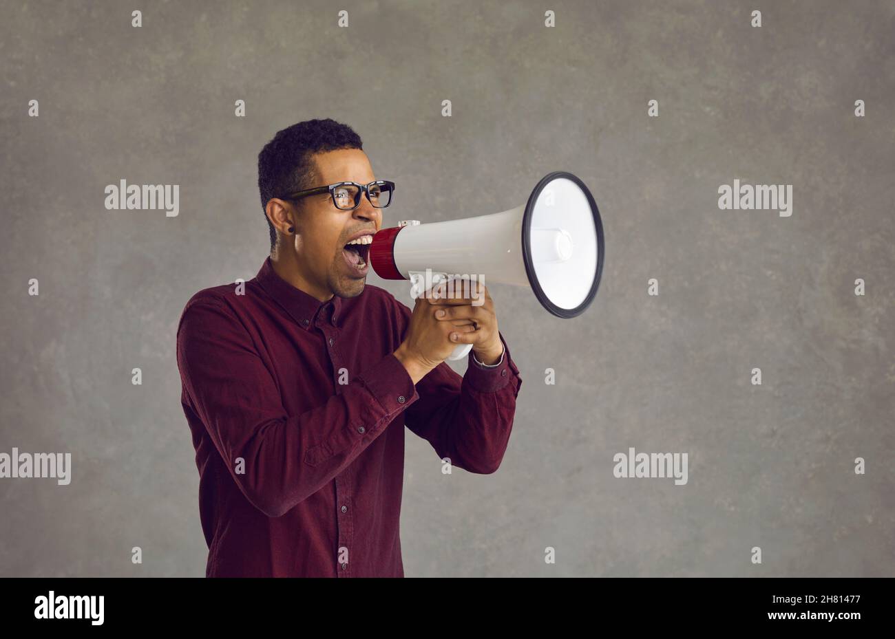 An excited crazy angry young African American man loudly shouting in a ...