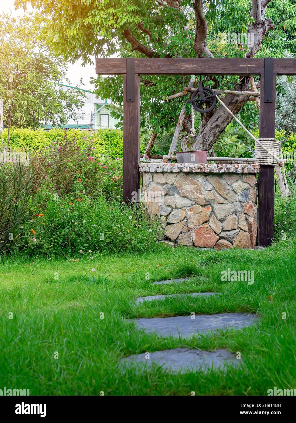 Beautiful artesian well made by stones and wheel pulley with metal ...