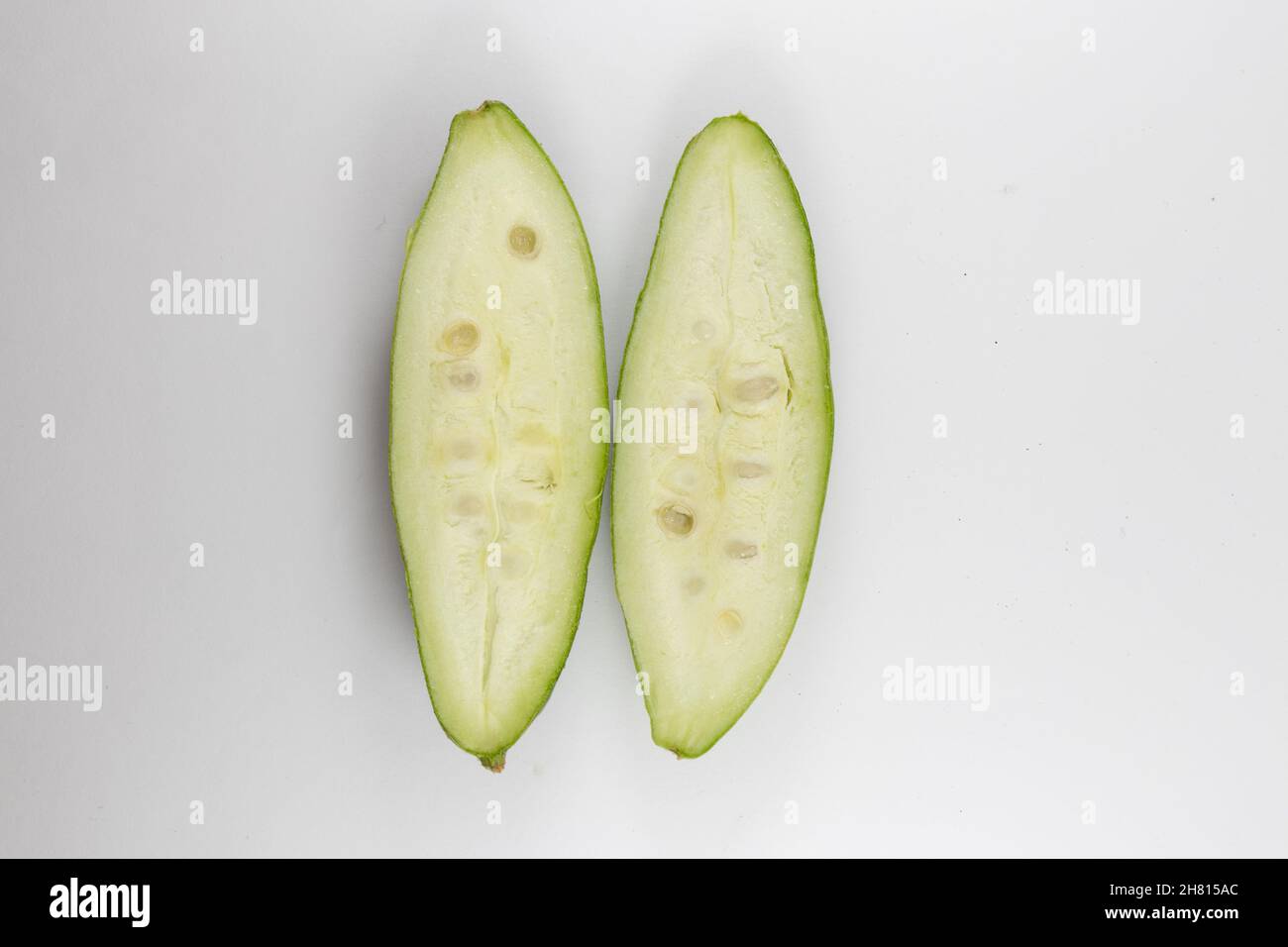 Top view of an unripe healthy organic fresh pointed gourd cut in half ...