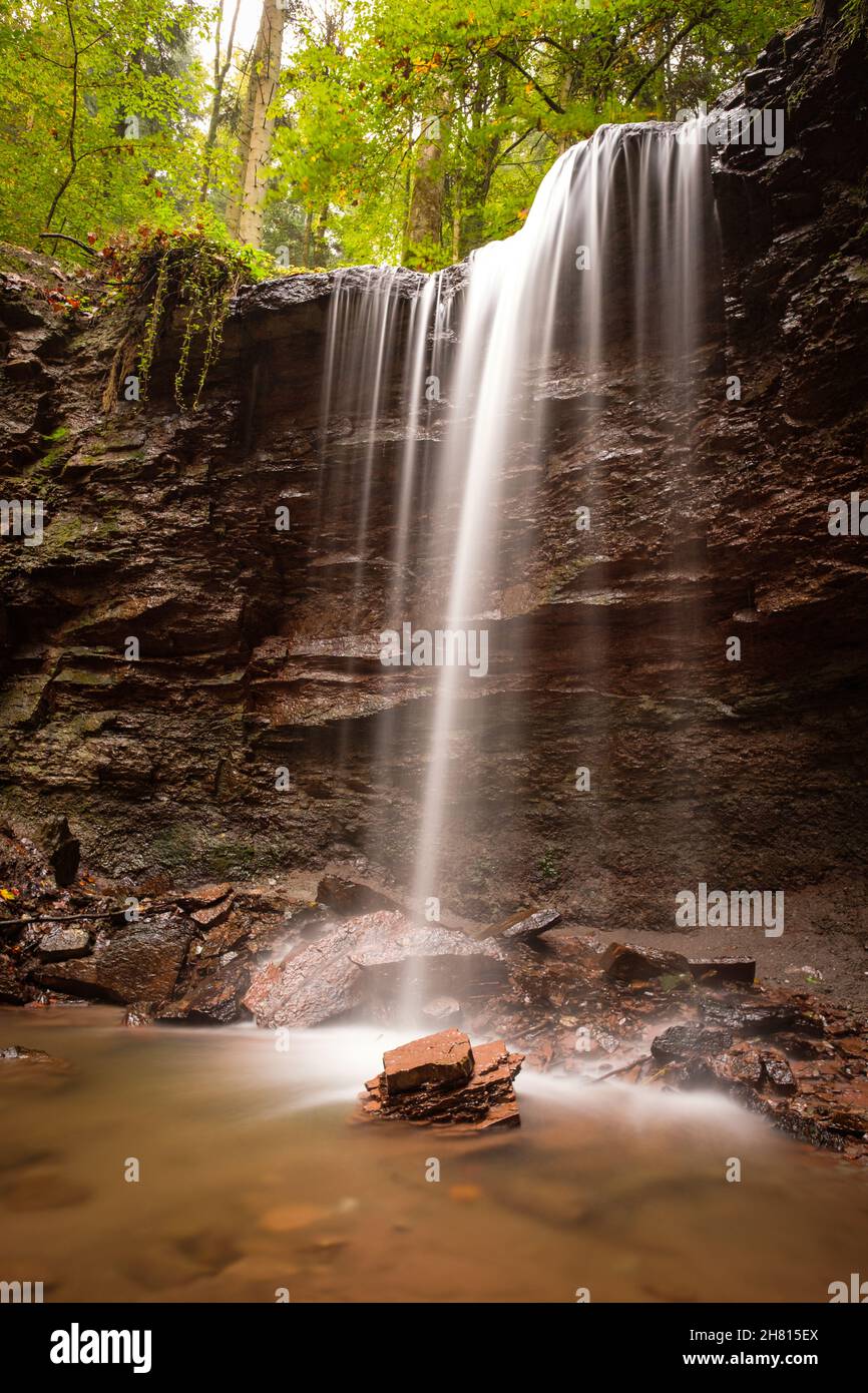 Stunning waterfall flowing over a rock in a forest Stock Photo - Alamy