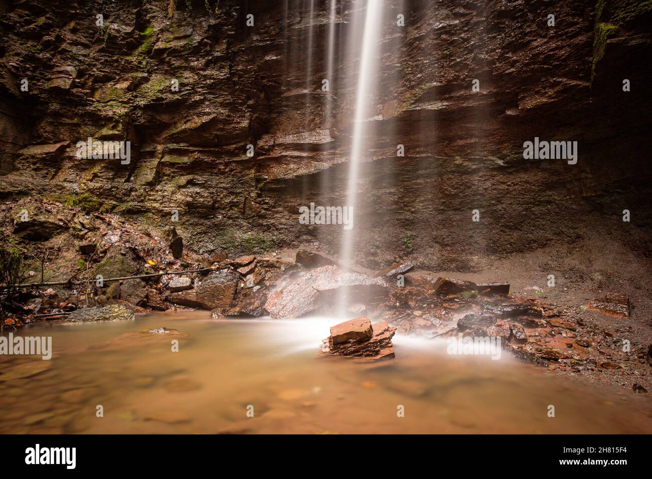 Falling water in a wild forest in Stock Photo - Alamy