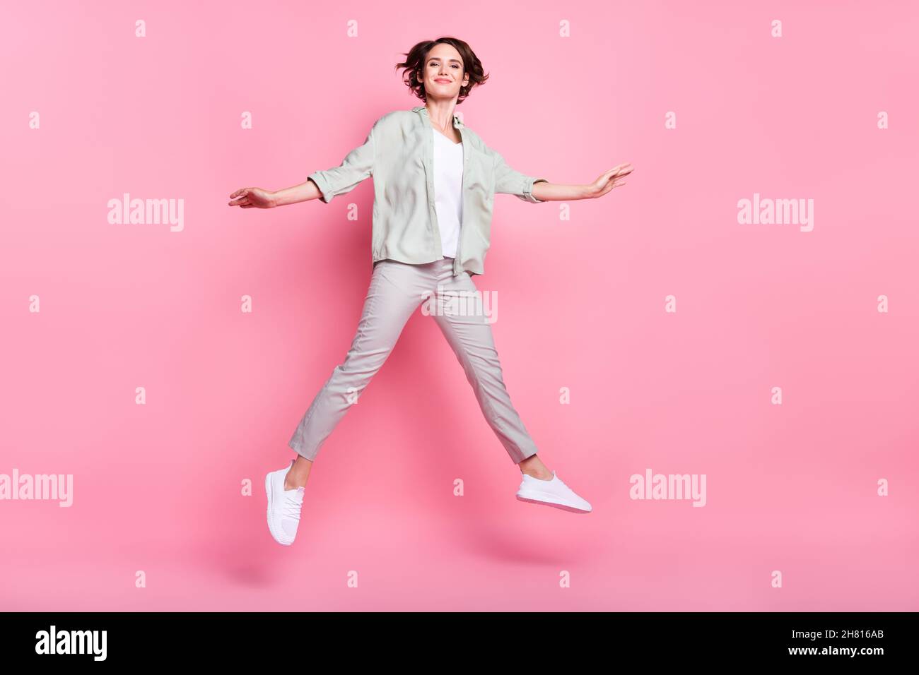 Photo of funny sweet young woman dressed beige clothes jumping high ...