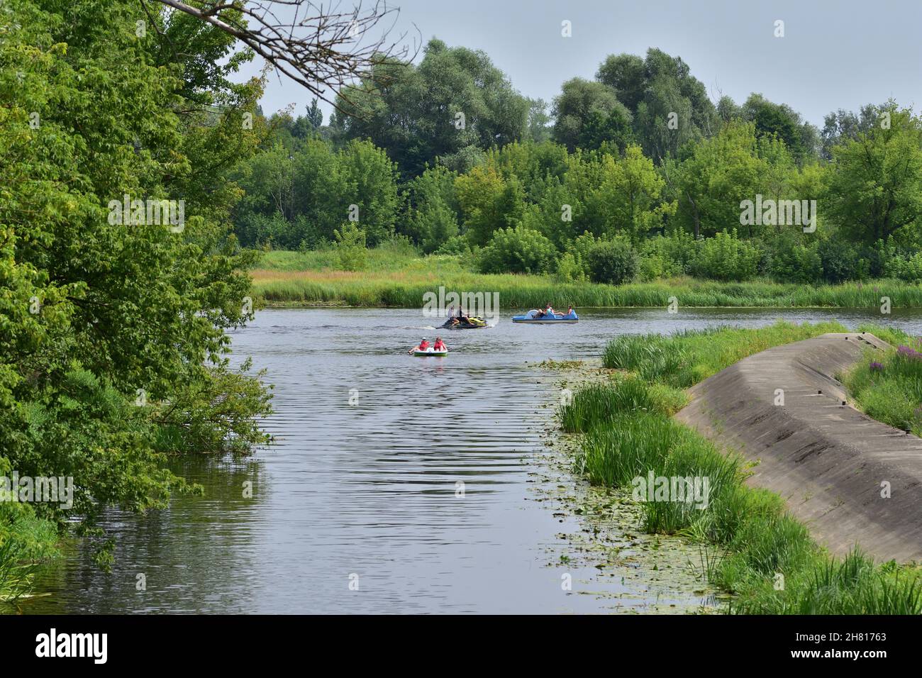 Canoes and boats flowing on the river on a sunny summer day during the ...