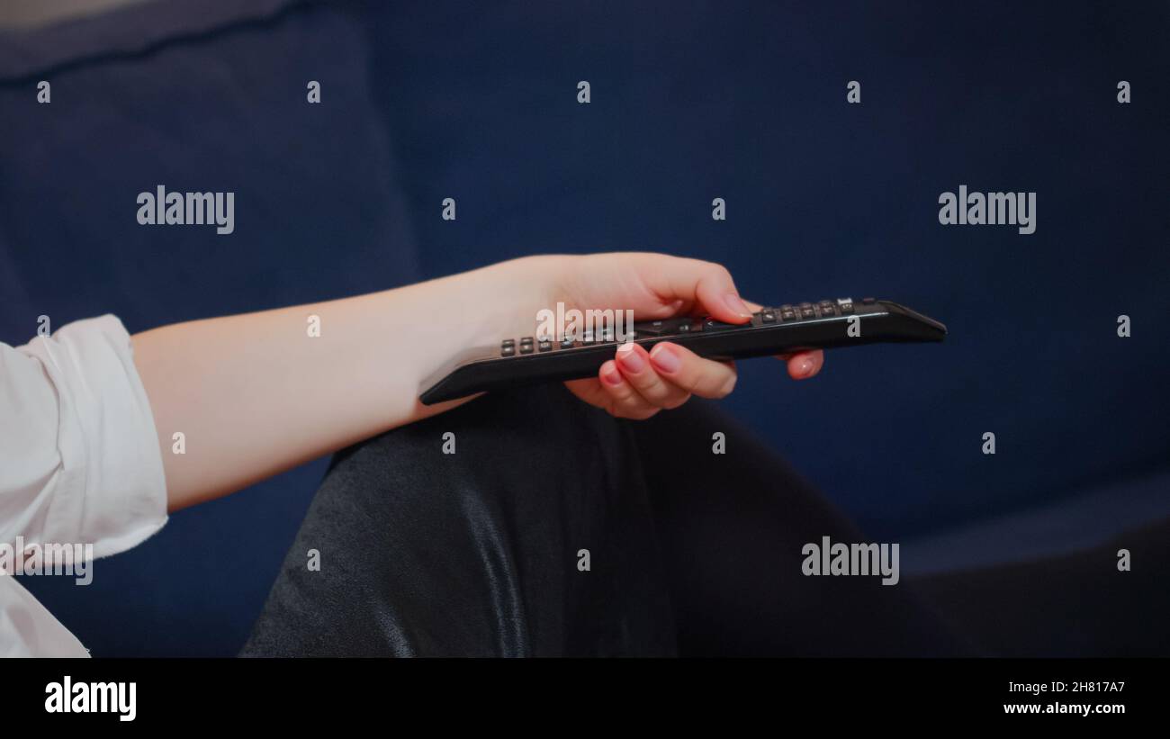 Close up of caucasian hand using remote controller for TV and searching ...