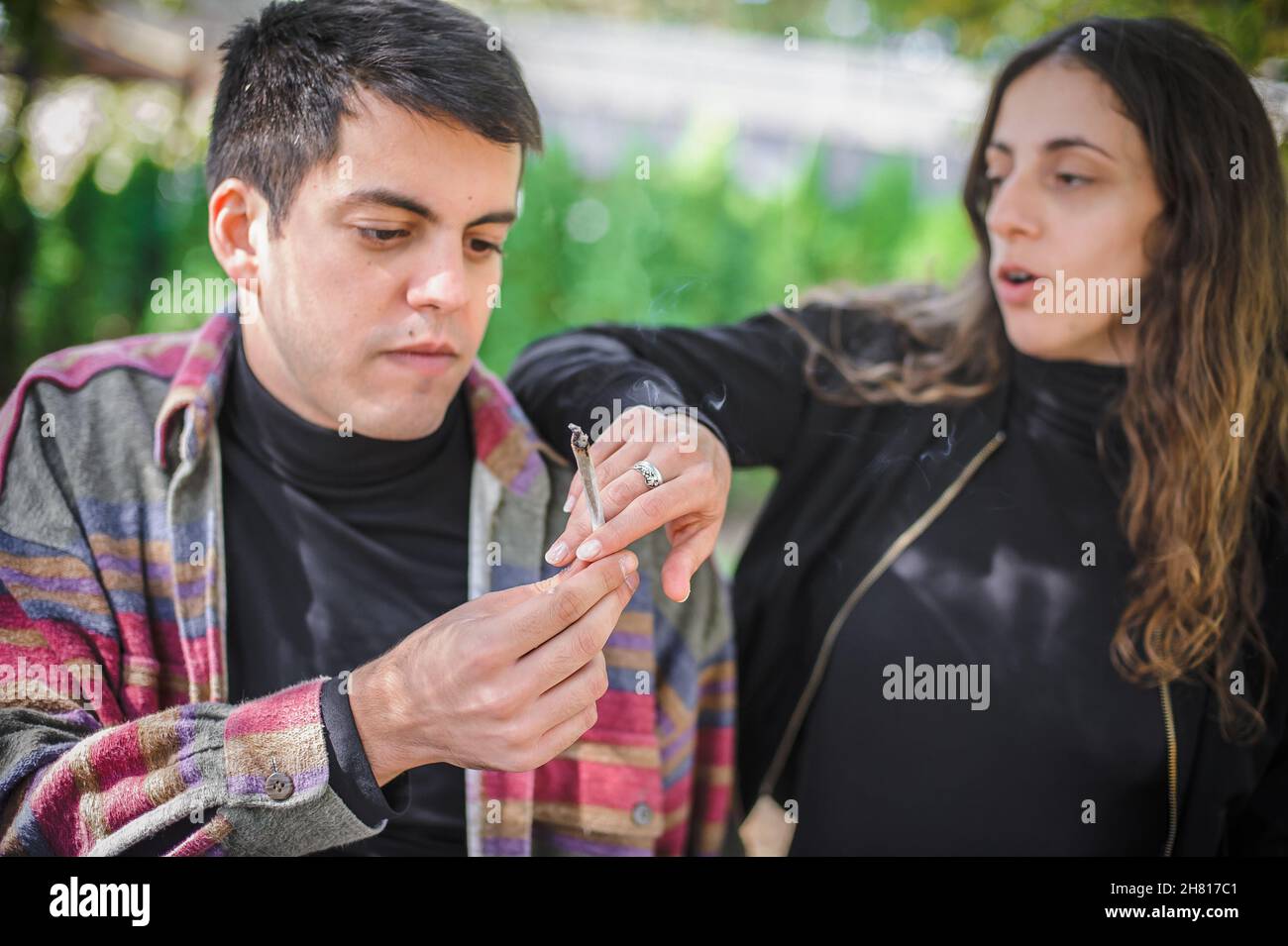 Young couple, woman and man, smoking cannabis marijuana ganja or ...