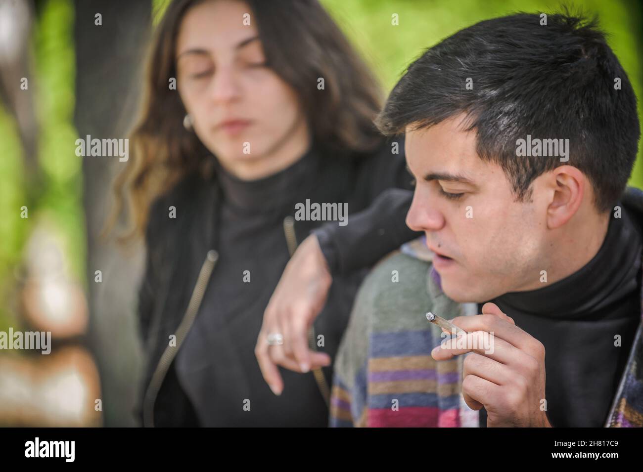 Young couple, woman and man, smoking cannabis marijuana ganja or ...