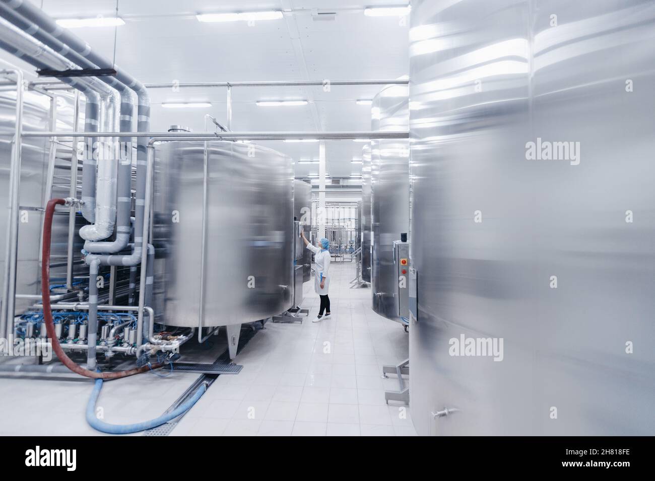 Worker female operator in uniform uses process control panel food ...