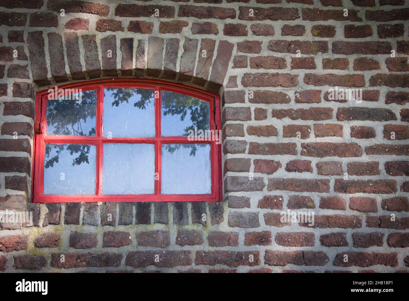 Brick wall with red-framed windows and copy space Stock Photo - Alamy