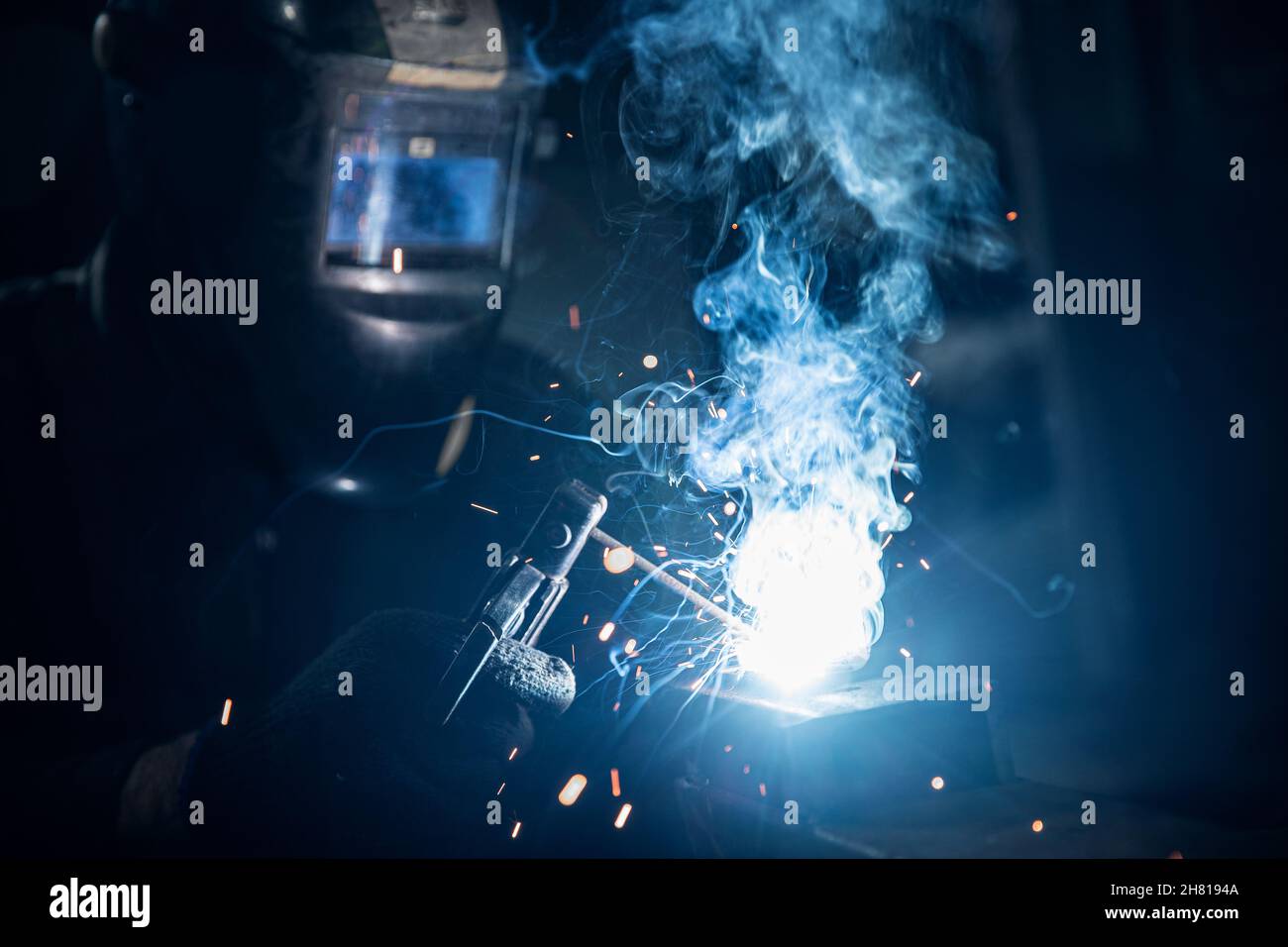 Industrial worker welder at factory use equipment mask and tool weld ...