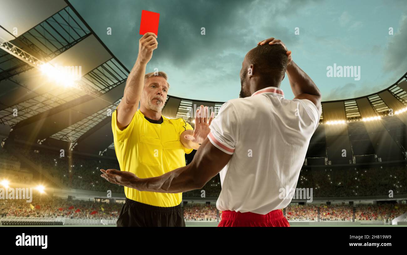 Football referee showing a player a red card for breaking rules at ...