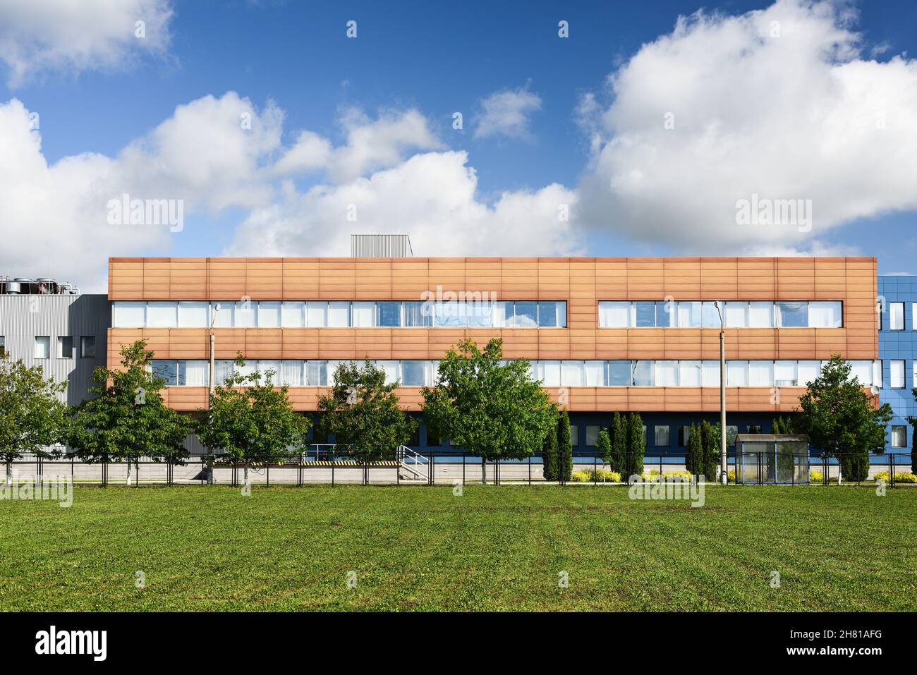 Modern factory building in green field with blue sky horizontal Stock ...