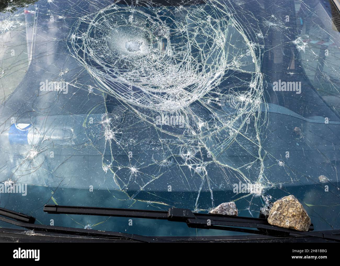 Car glass shattered by a stone. Broken car windshield. Criminal ...