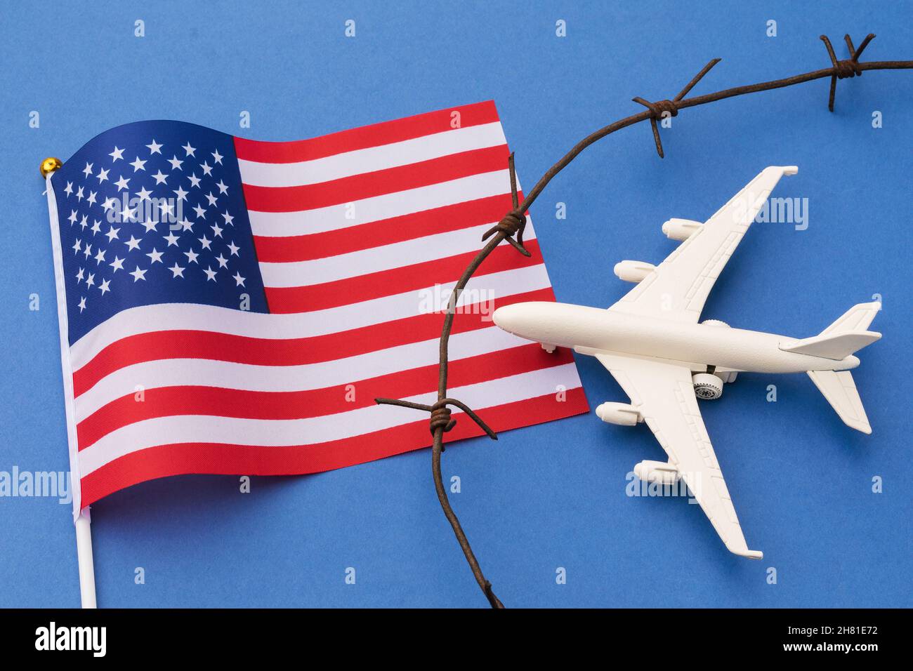 USA flag, barbed wire and toy plane on blue background, American air ...