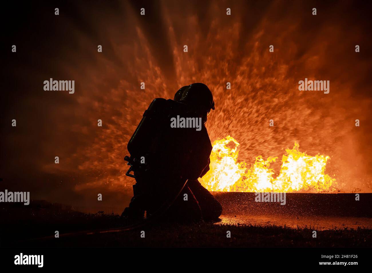 Firefighter training, fireman using water and extinguisher to fighting ...